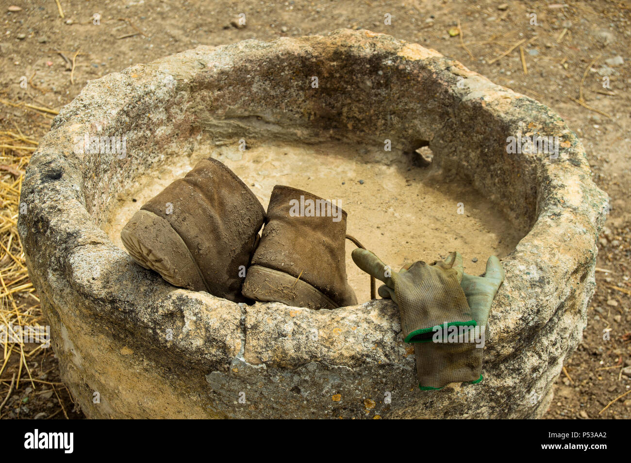 Old and diirty working boots and gloves in the field pit Stock Photo ...