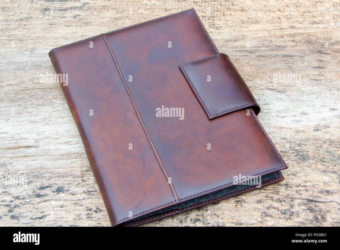 Brown leather organizer planner on the wooden backgrounde. Front and ...