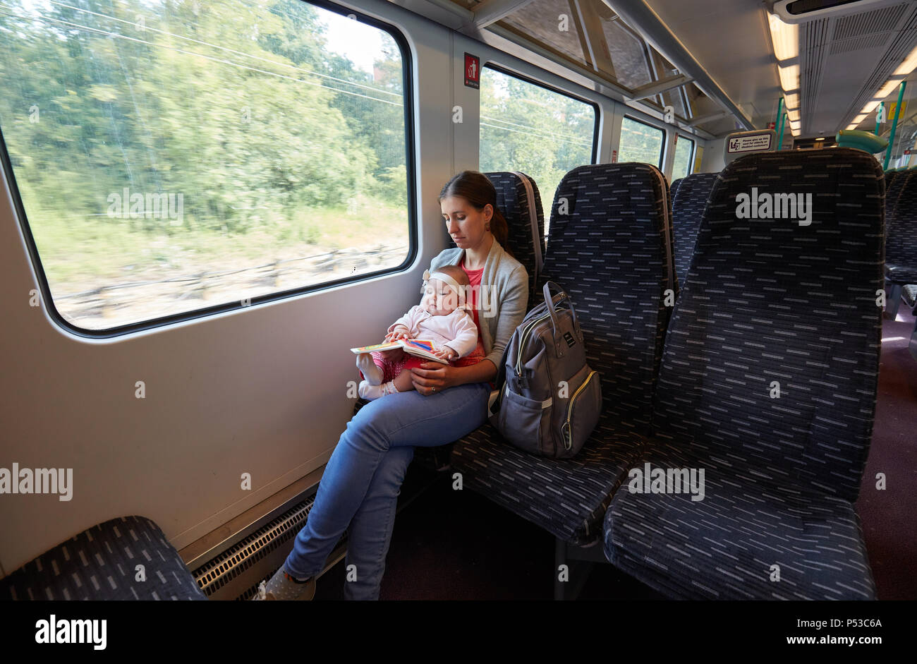 Young mother travelling with baby girl on the train between London and ...