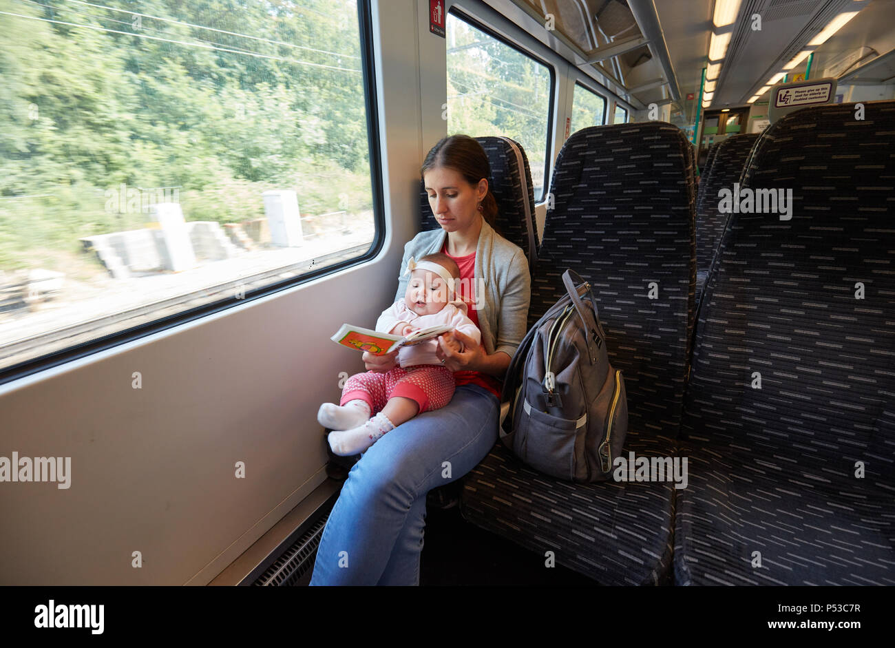 Young mother travelling with baby girl on the train between London and ...