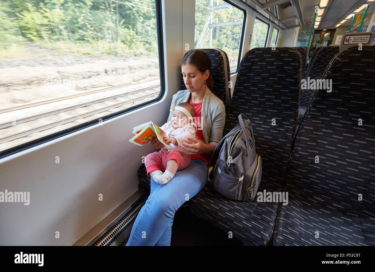 Young mother travelling with baby girl on the train between London and ...