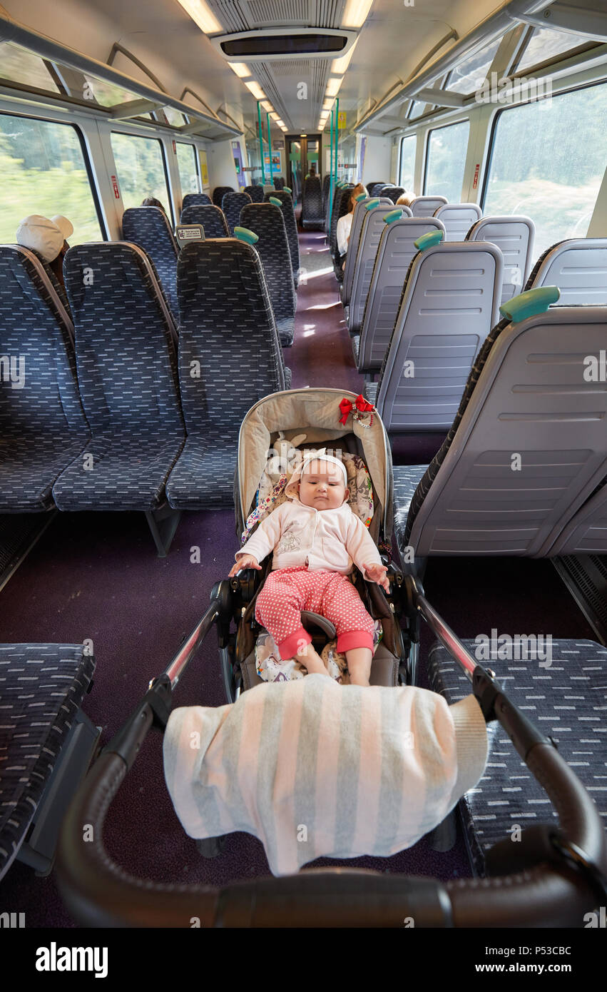 Young mother travelling with baby girl on the train between London and ...