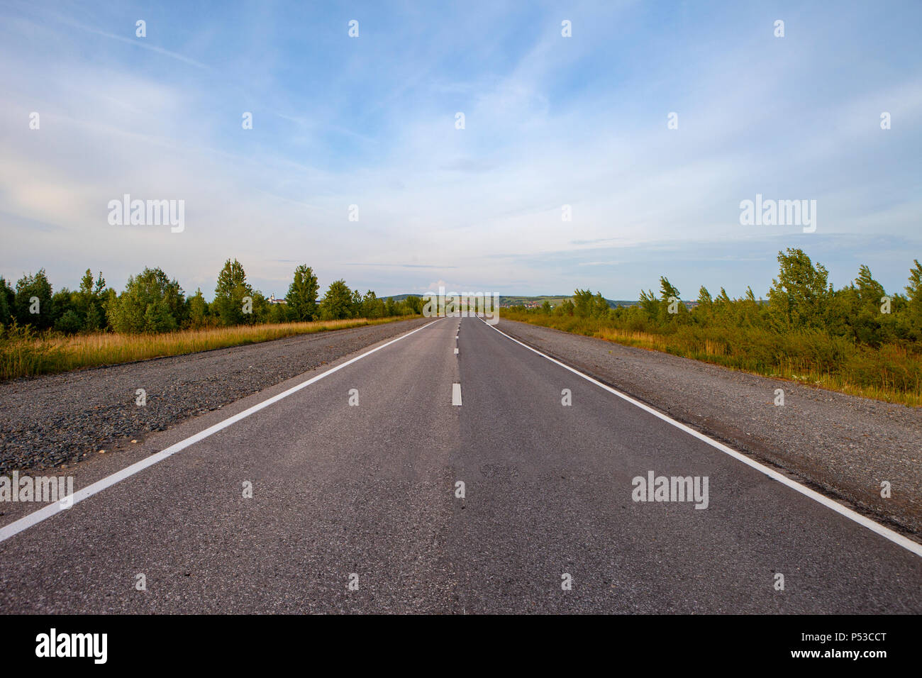 An empty road leading to the village on the hills Stock Photo - Alamy