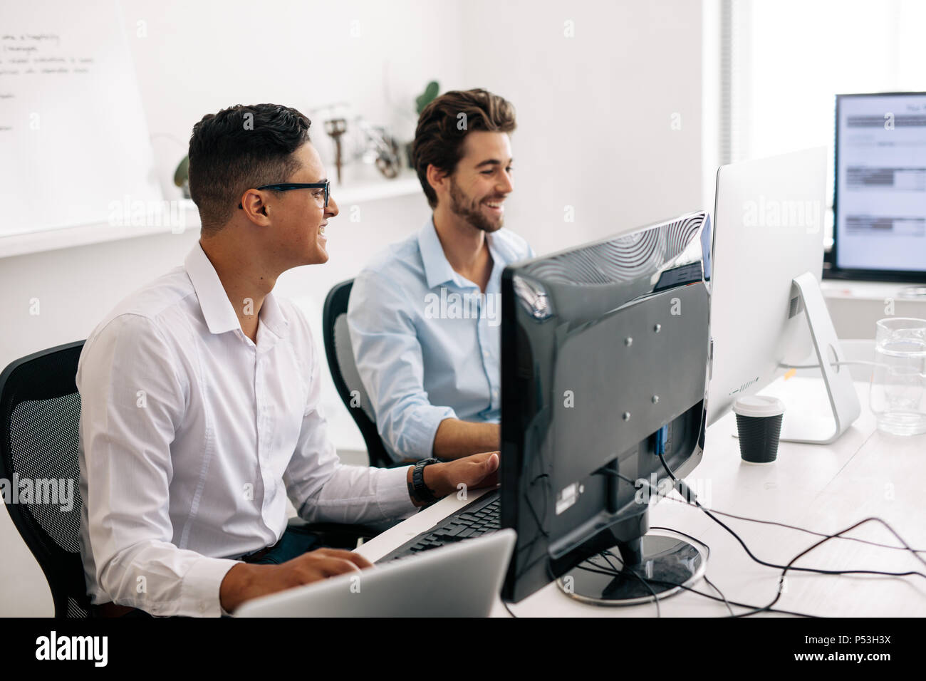 Software Developers Sitting At Office Working On Computers Smiling Application Developers