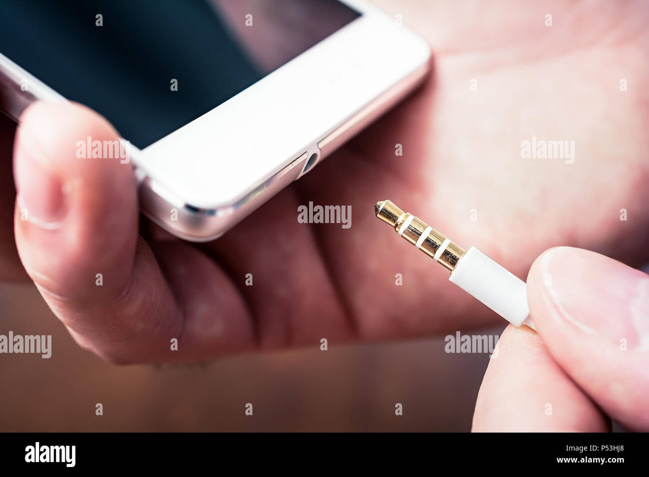 Headphone Jack Of A White Smartphone Gets Plugged In A White Headset ...