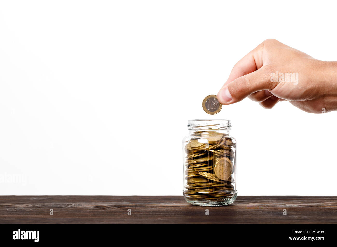 hand put money coins to glass jar Stock Photo - Alamy