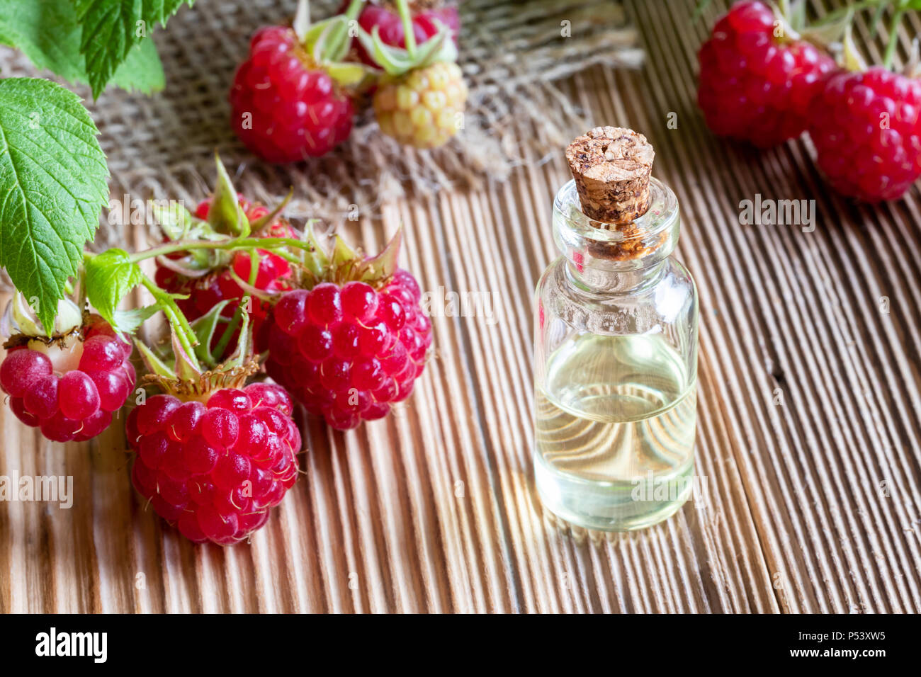 A bottle of raspberry seed oil with fresh fruit Stock Photo - Alamy
