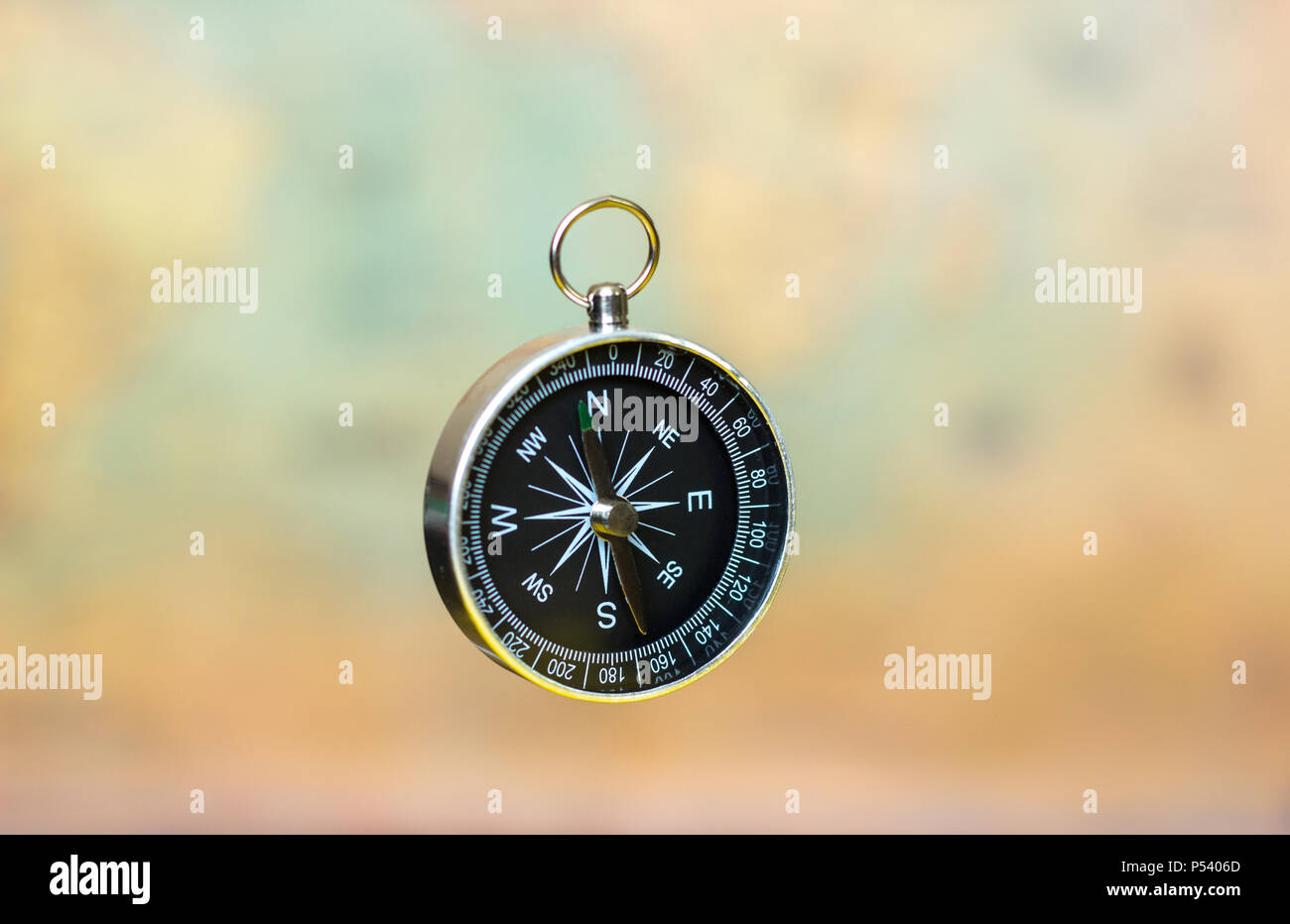 compass on a blurry background with a vintage world map Stock Photo - Alamy