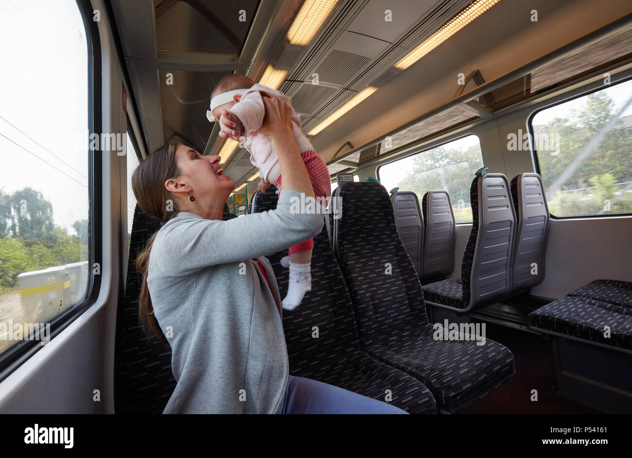 Young mother travelling with baby girl on the train Stock Photo - Alamy