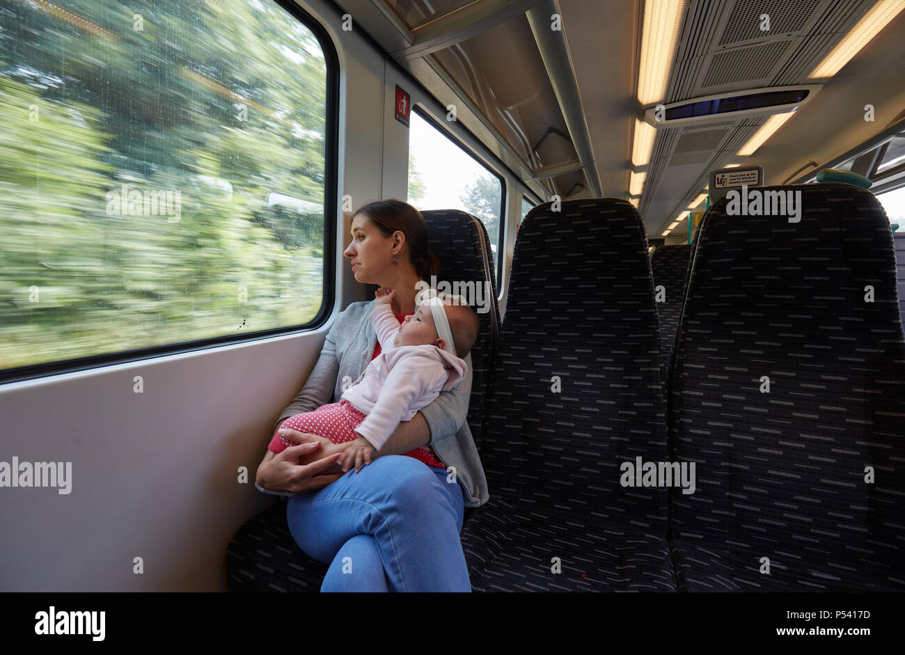 Young mother travelling with baby girl on the train Stock Photo - Alamy