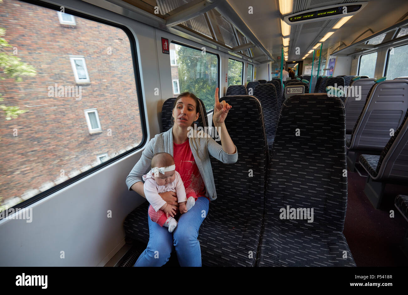 Young mother travelling with baby girl on the train Stock Photo - Alamy