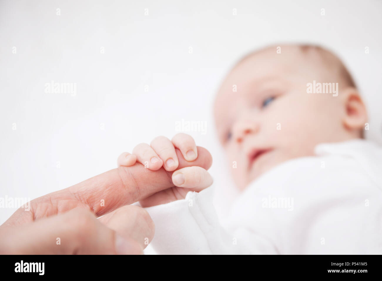 Newborn baby hand holds mother finger. Isolated on white background ...