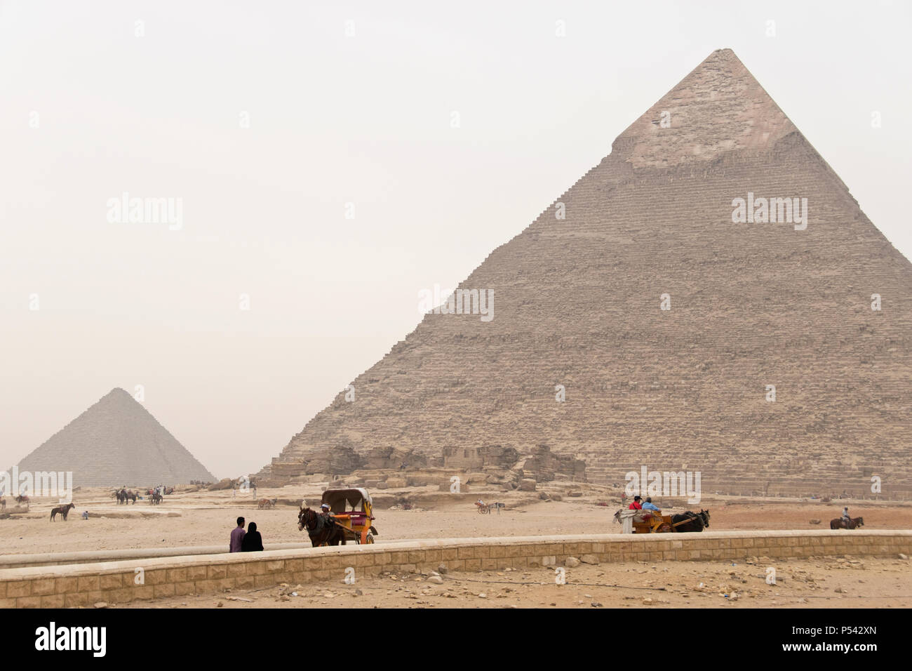 Horse drawn carriages carry tourists to the Pyramid of Khafre (Chephren ...