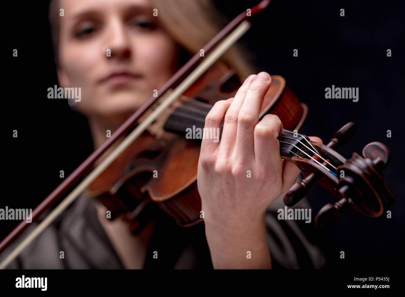 focus on the hand of a baroque violinist player on a black background ...