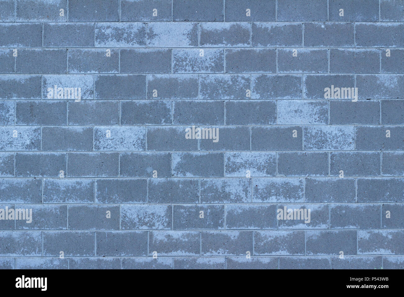 Close-up view of an exterior cinder block cement wall with naturally ...