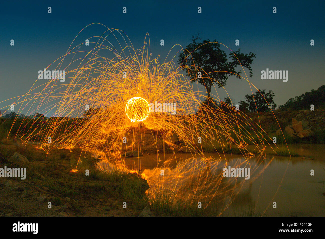 burning steel wool on the mountain rock above lagoon Stock Photo - Alamy