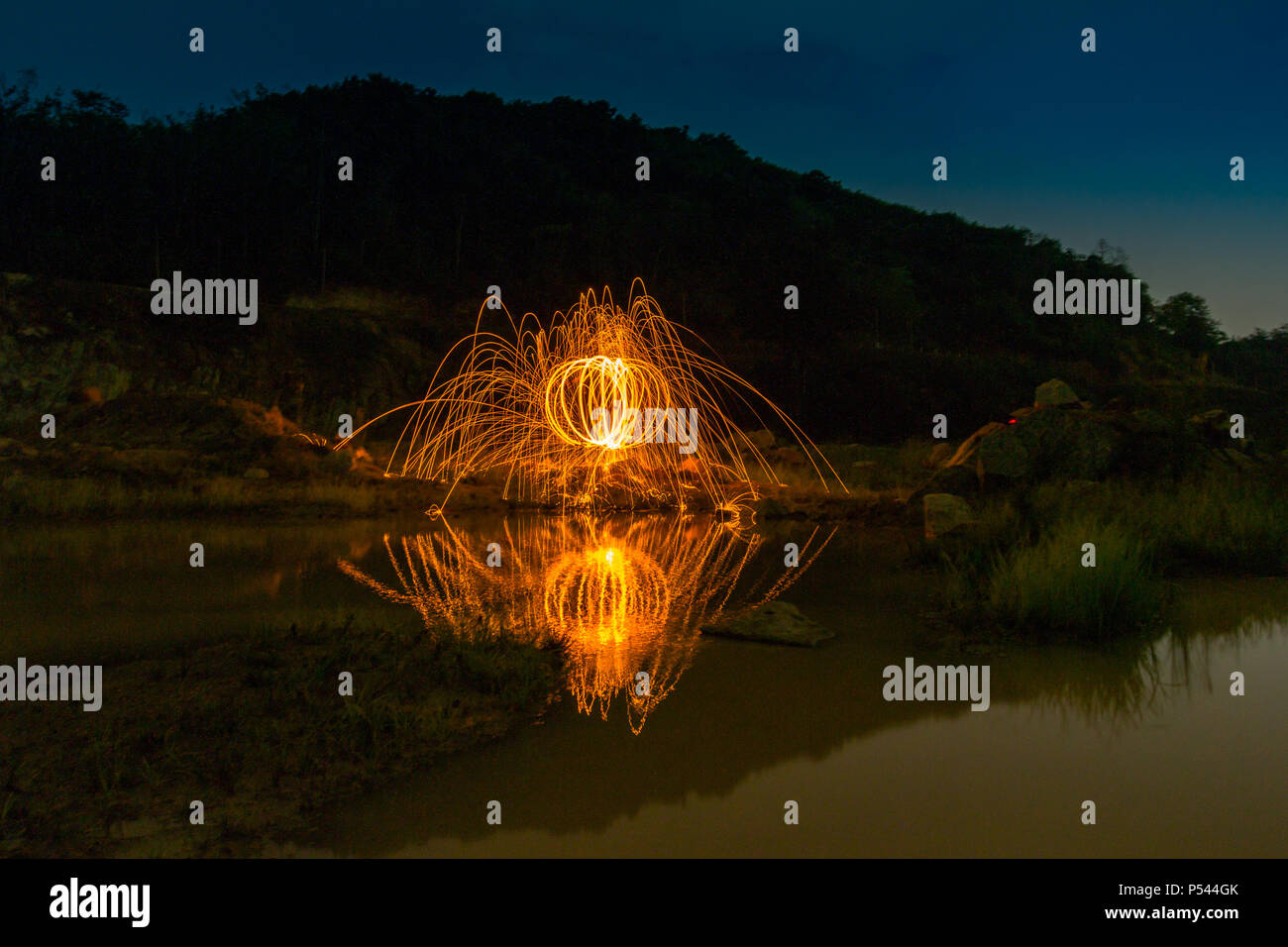 burning steel wool on the mountain rock above lagoon Stock Photo - Alamy