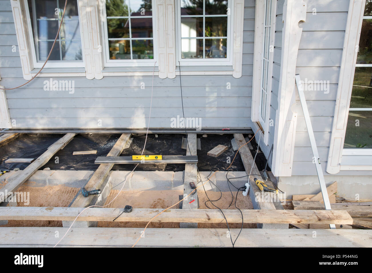 Installing a wood floor outdoor terrace in new house construction site ...
