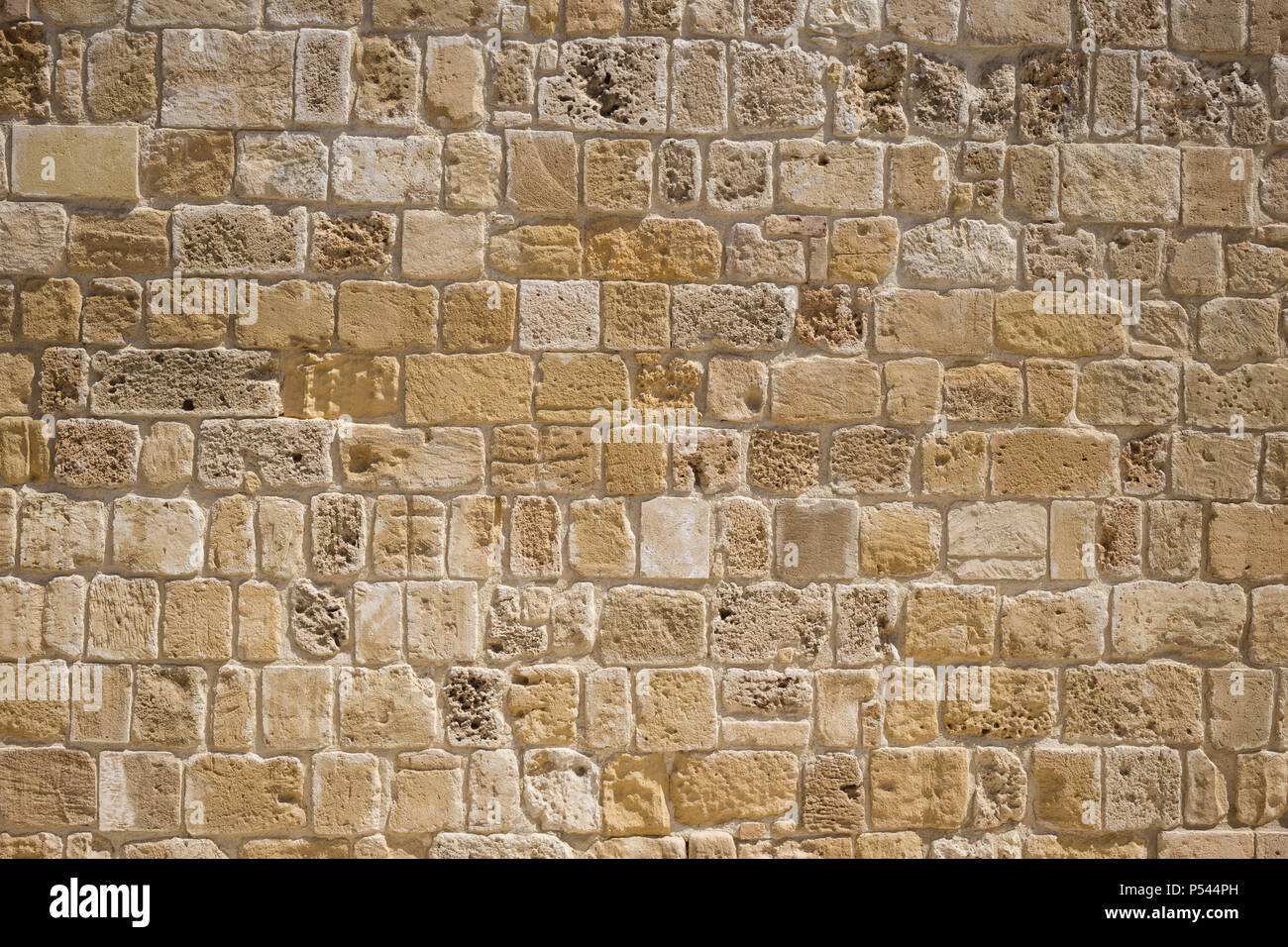 Sandstone, limestone aged wall at Cyprus. Yellow stonewall backdrop ...