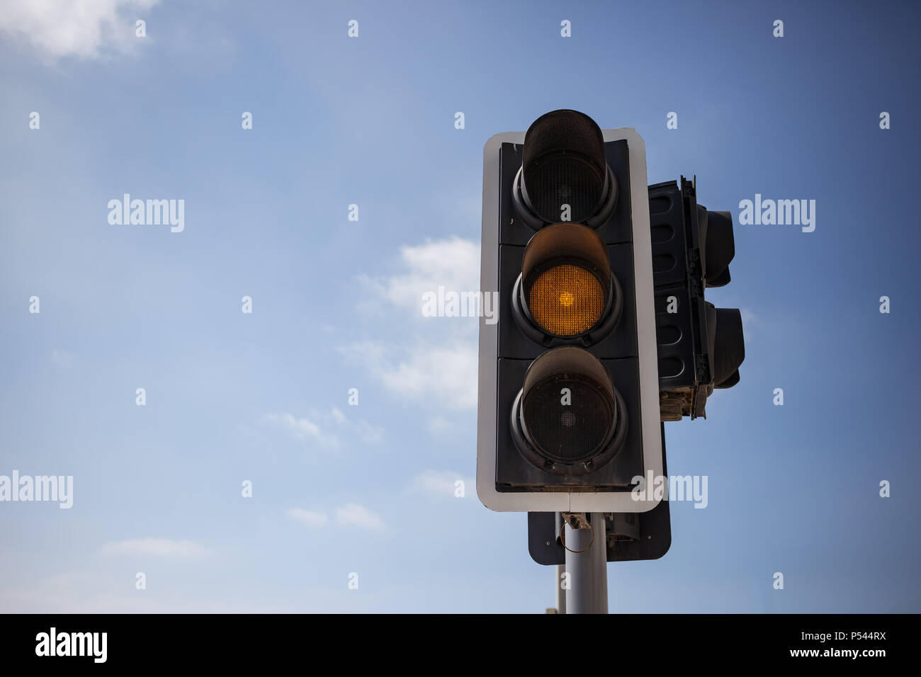 Yellow, orange color traffic light. Blue sky with few clouds background ...