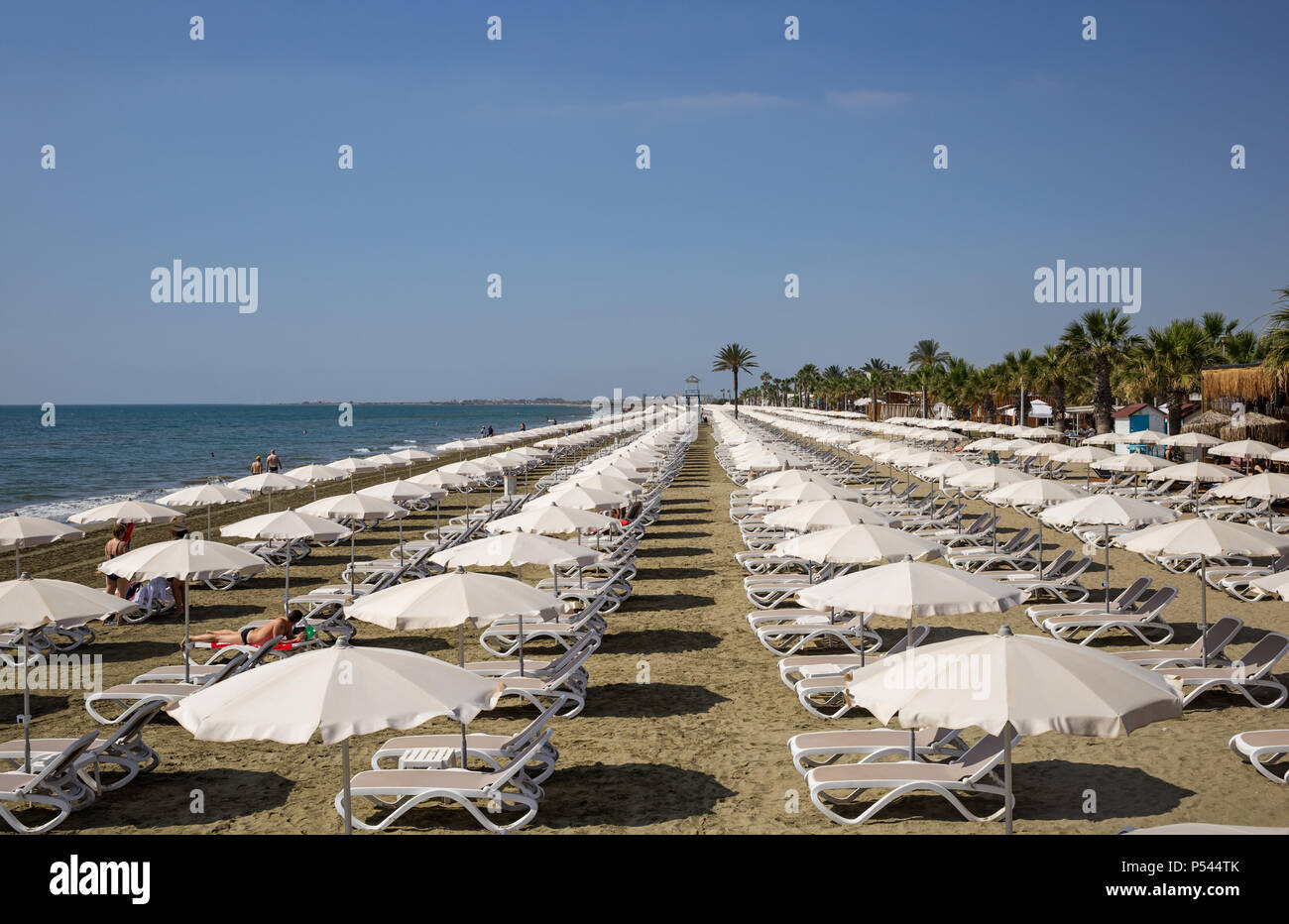 Mackenzie sandy beach at Larnaca, Cyprus. Sun loungers and umbrellas ...