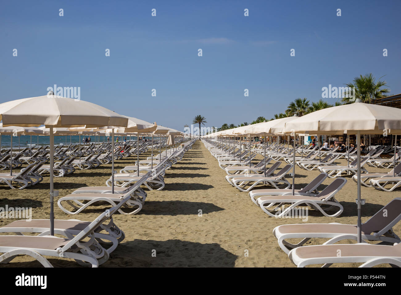 Mackenzie sandy beach at Larnaca, Cyprus. Sun loungers and umbrellas ...