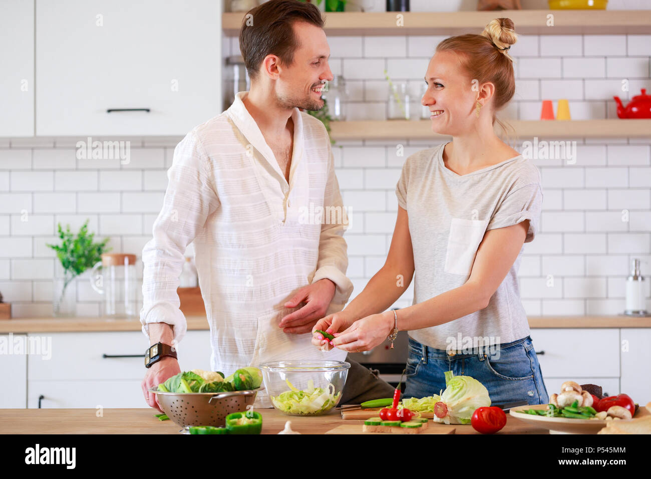 Picture of loving couple cooking vegetables in kitchen Stock Photo - Alamy