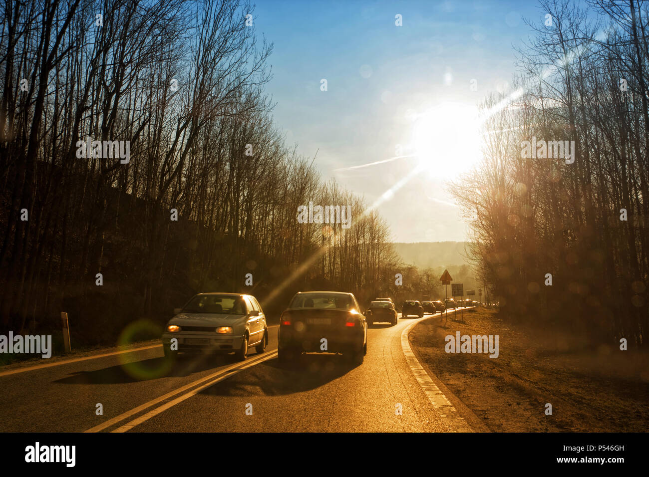 Cars driving down country road Stock Photo - Alamy