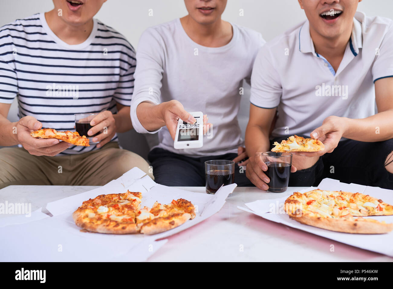 Positive joyful friends enjoying their pizza Stock Photo - Alamy