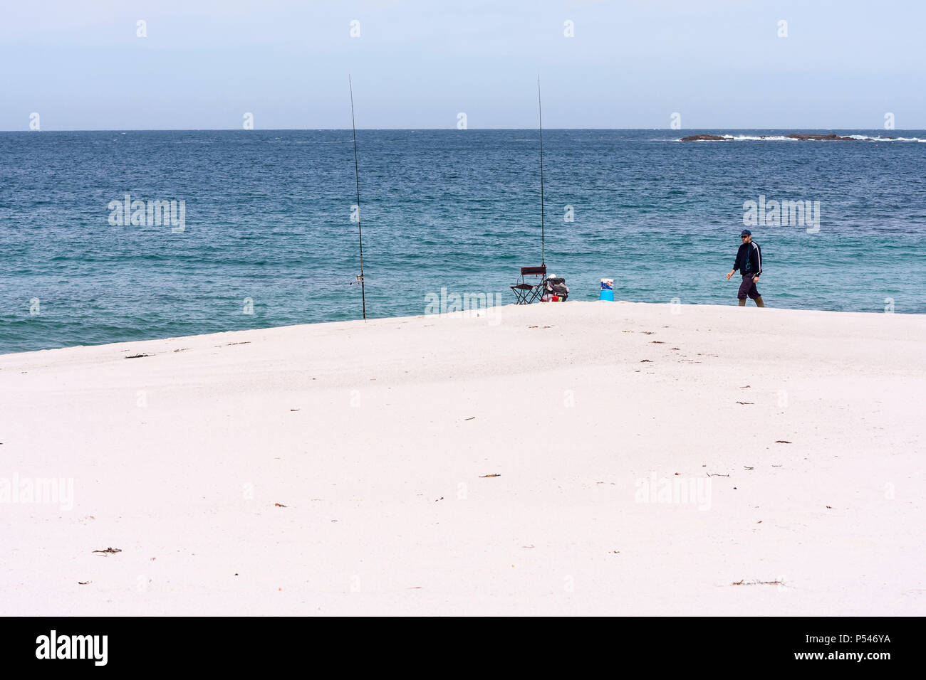 Fisherman fishing from the sand on the beach Stock Photo - Alamy