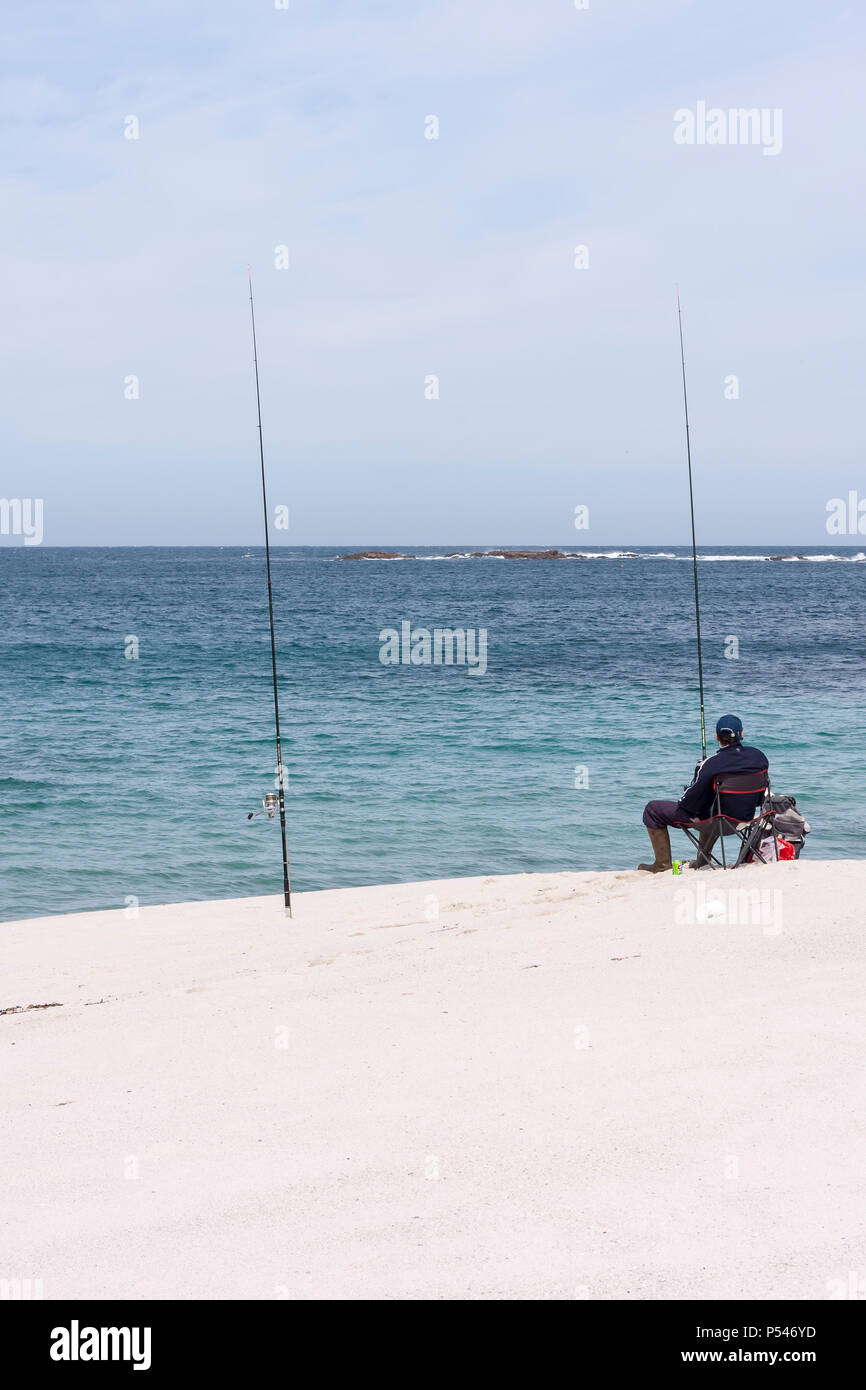 Fisherman fishing from the sand on the beach Stock Photo - Alamy