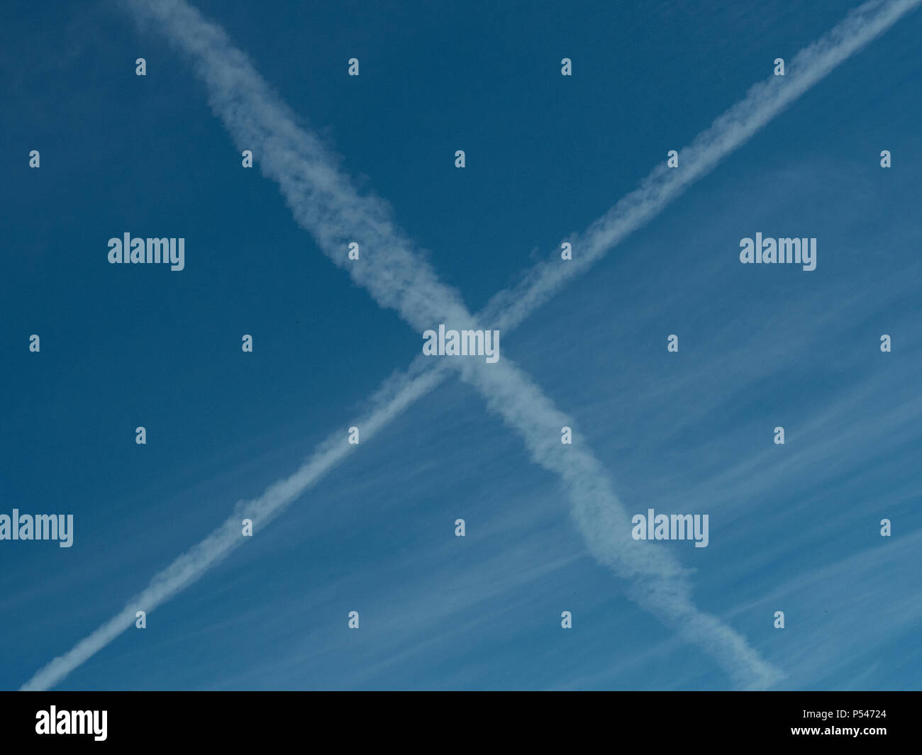 A cross formed in on a blue sky by two crossing jet trails Stock Photo ...