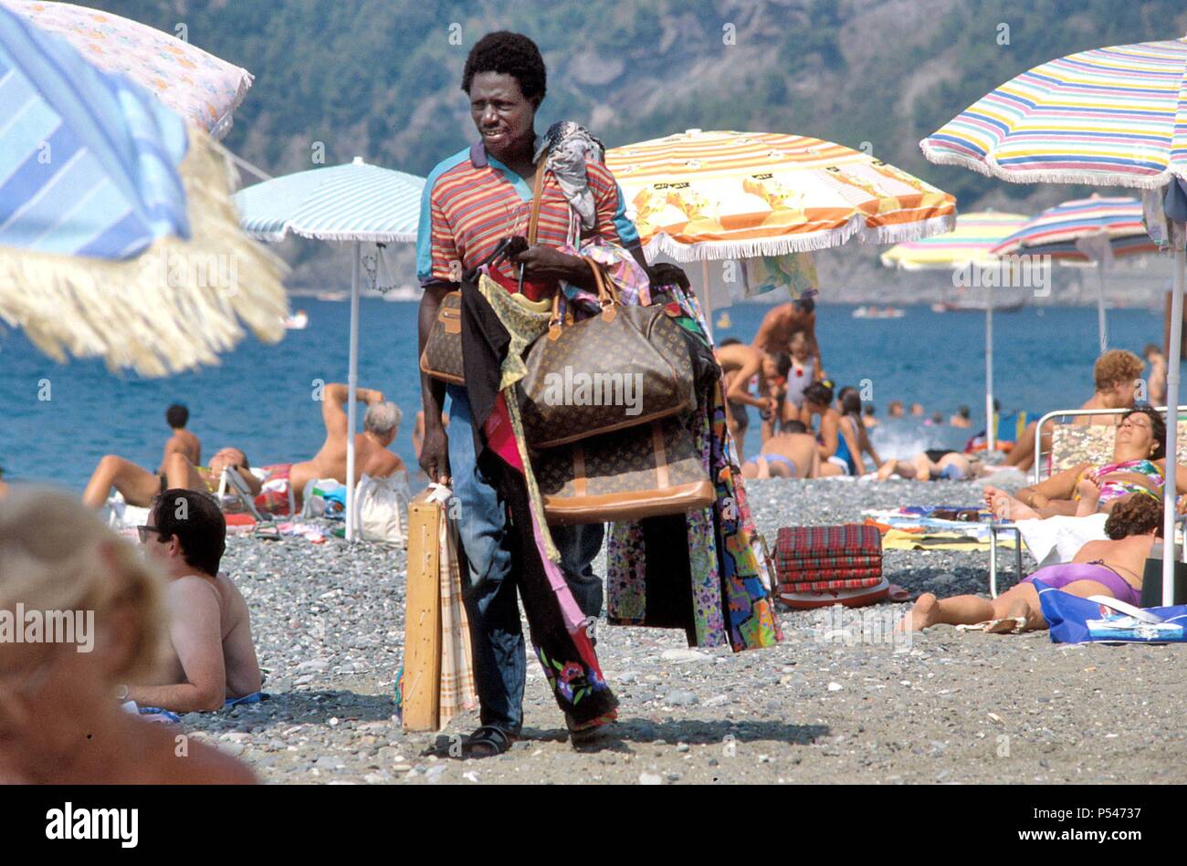 African immigrant street vendor on the beach of Riva Trigoso (Liguria ...