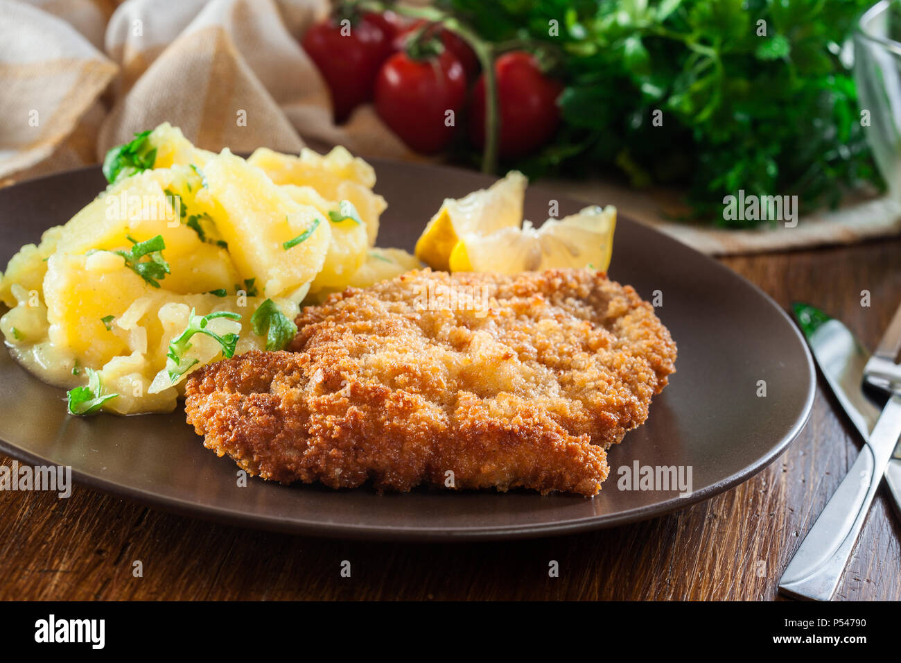 Homemade breaded viennese schnitzel with potato salad on a plate Stock ...