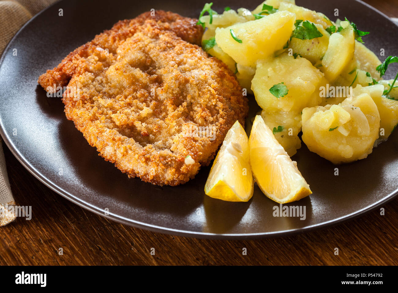 Homemade breaded viennese schnitzel with potato salad on a plate Stock ...