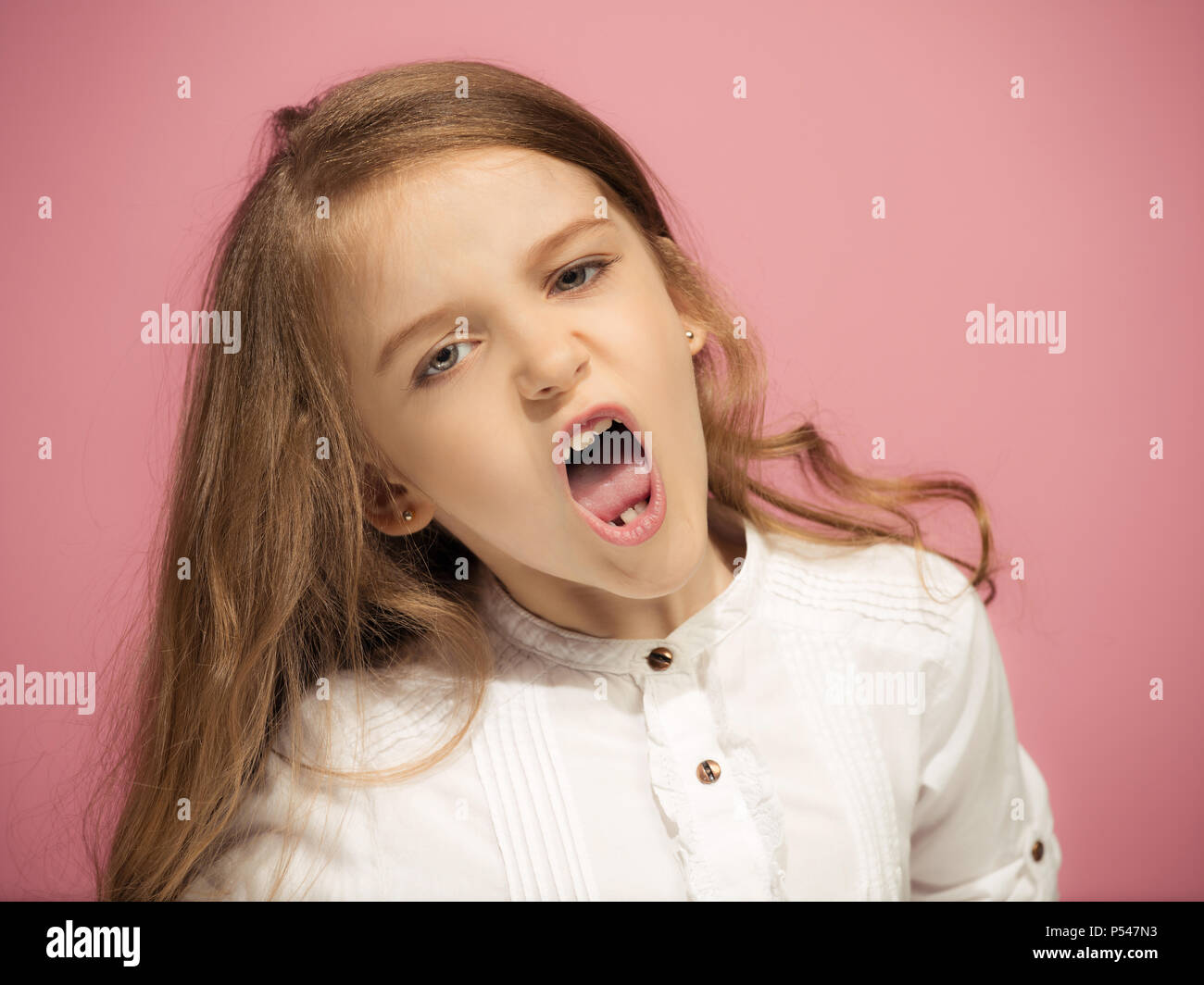Portrait of angry teen girl on a pink studio background Stock Photo - Alamy