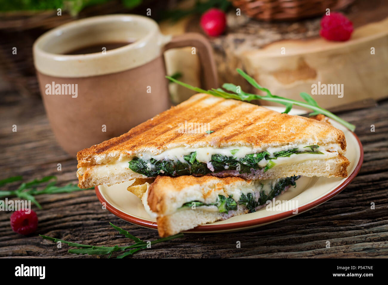 Panini sandwich with cheese and mustard leaves. Morning coffee. Village ...