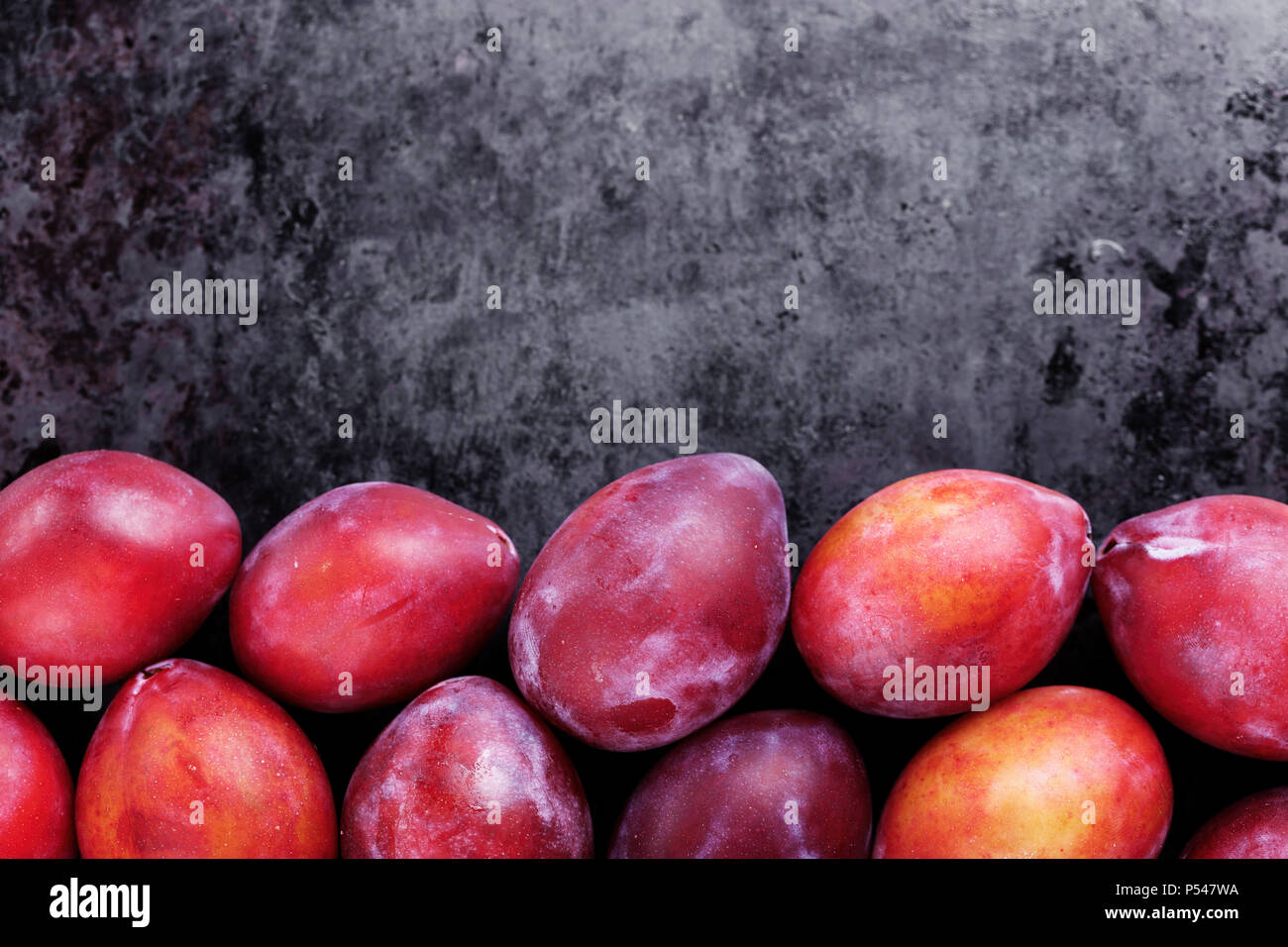 ripe plums scattered on a black background, space for text Stock Photo ...