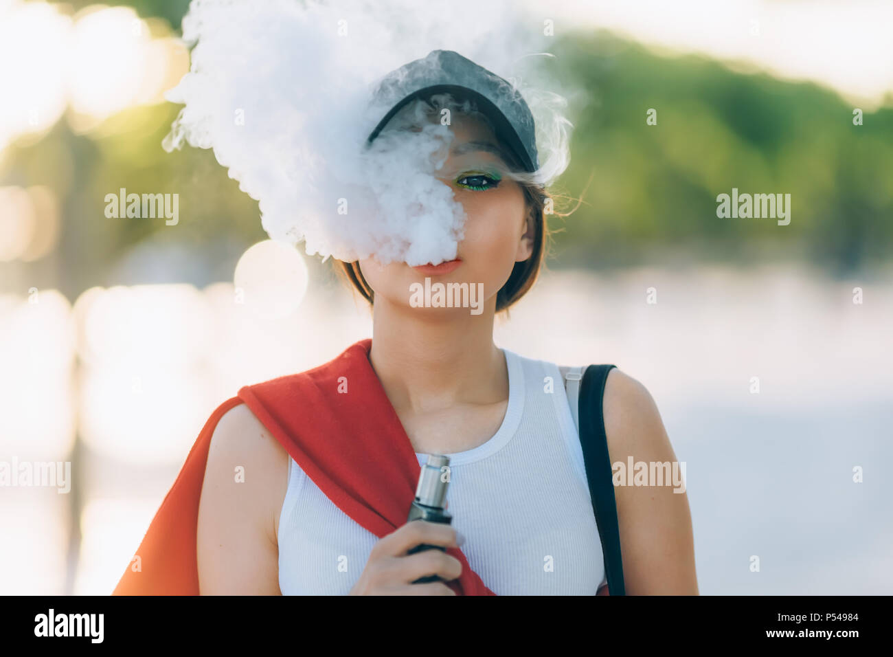 Pretty young asian girl vape popular ecig gadget,vaping device.Happy ...