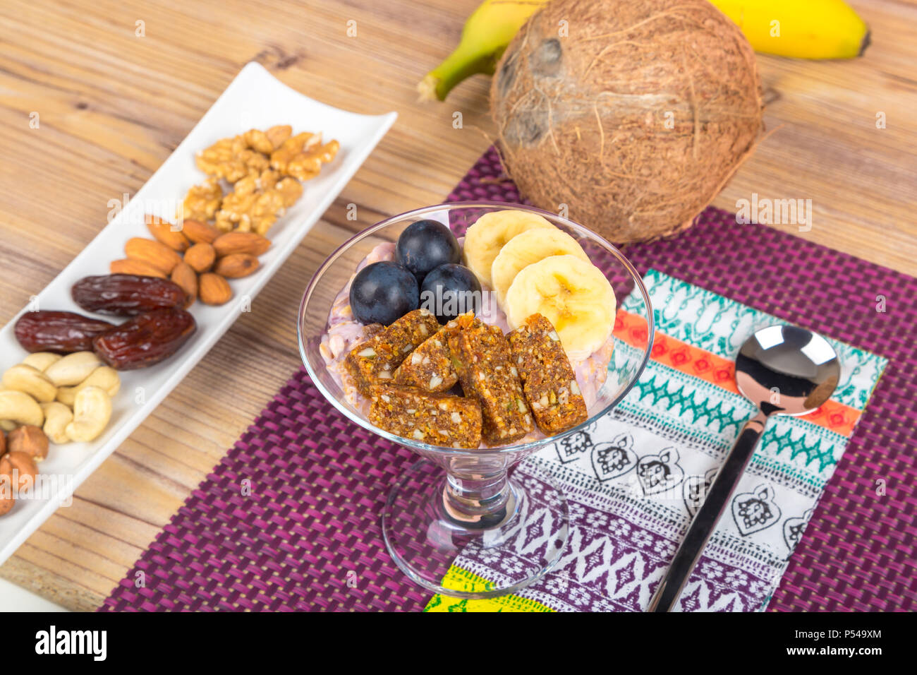Close up view of cup and raw vegan energy sweets, bars with mix of ...