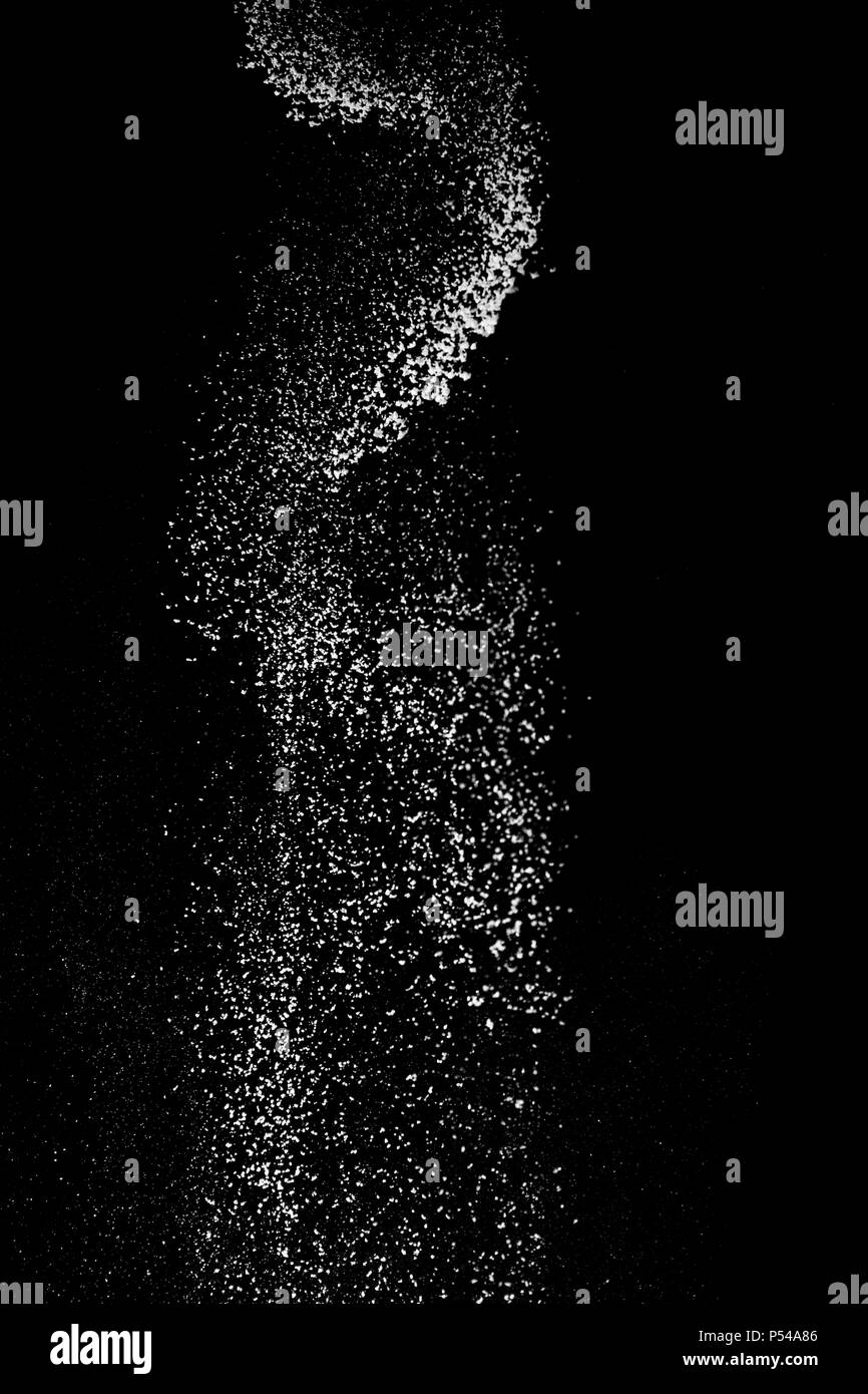 White powder splash isolated on black background. Flour sifting on a ...
