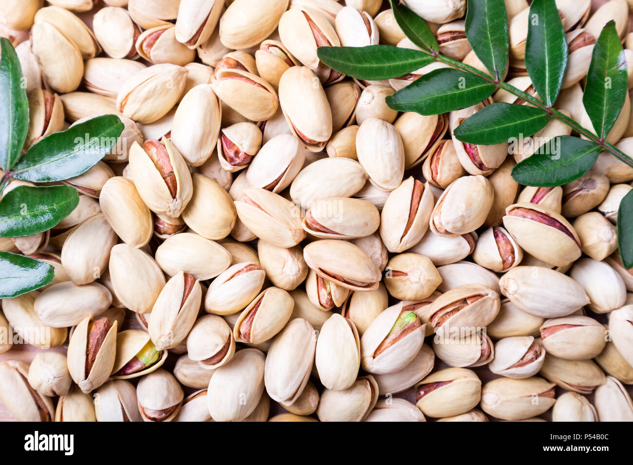 Pistachio background. Pistachio texture with leaves. Nuts. Top view ...