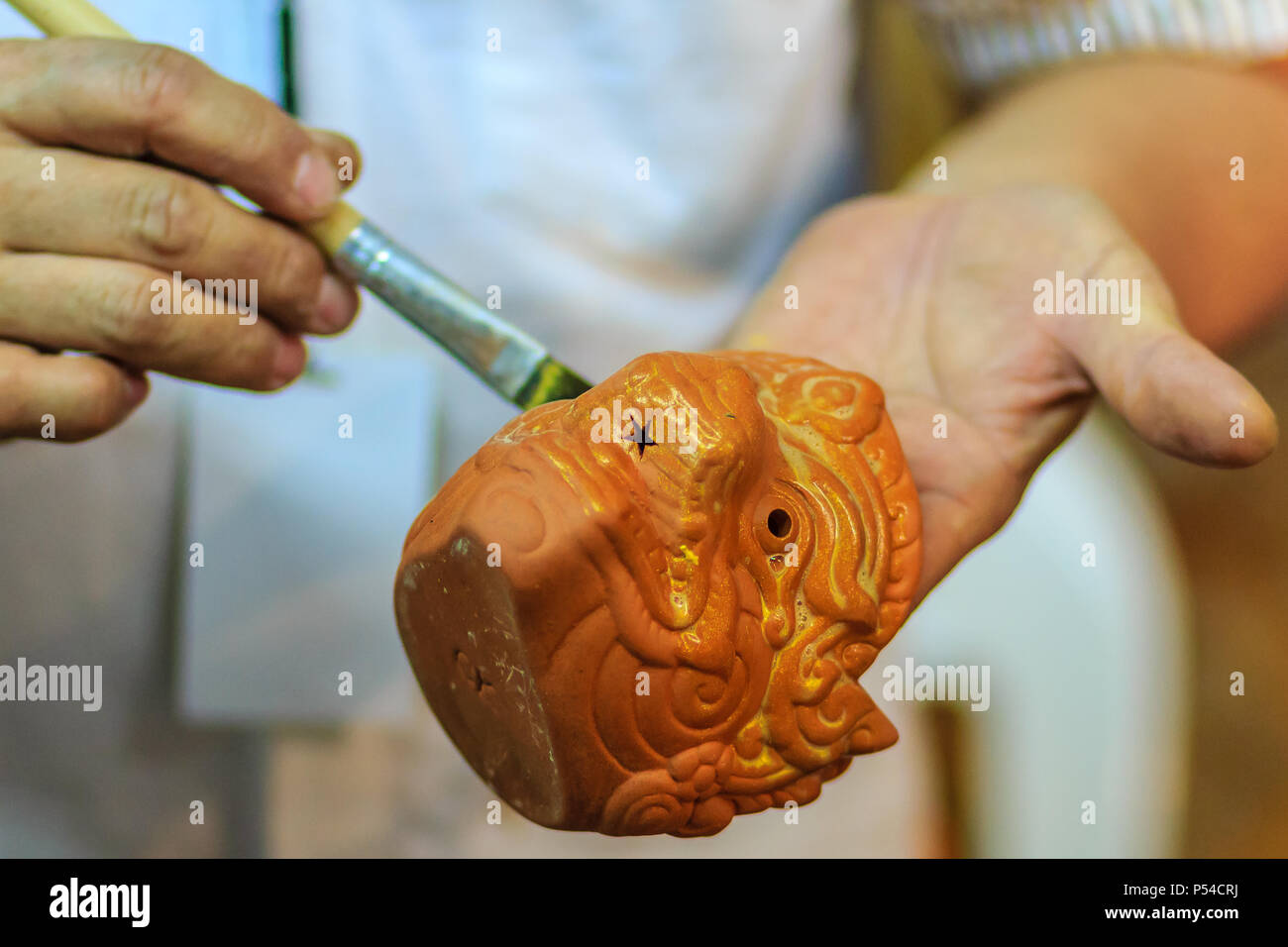 Close up hand of Thai sculptor during painting the masterpiece of ...