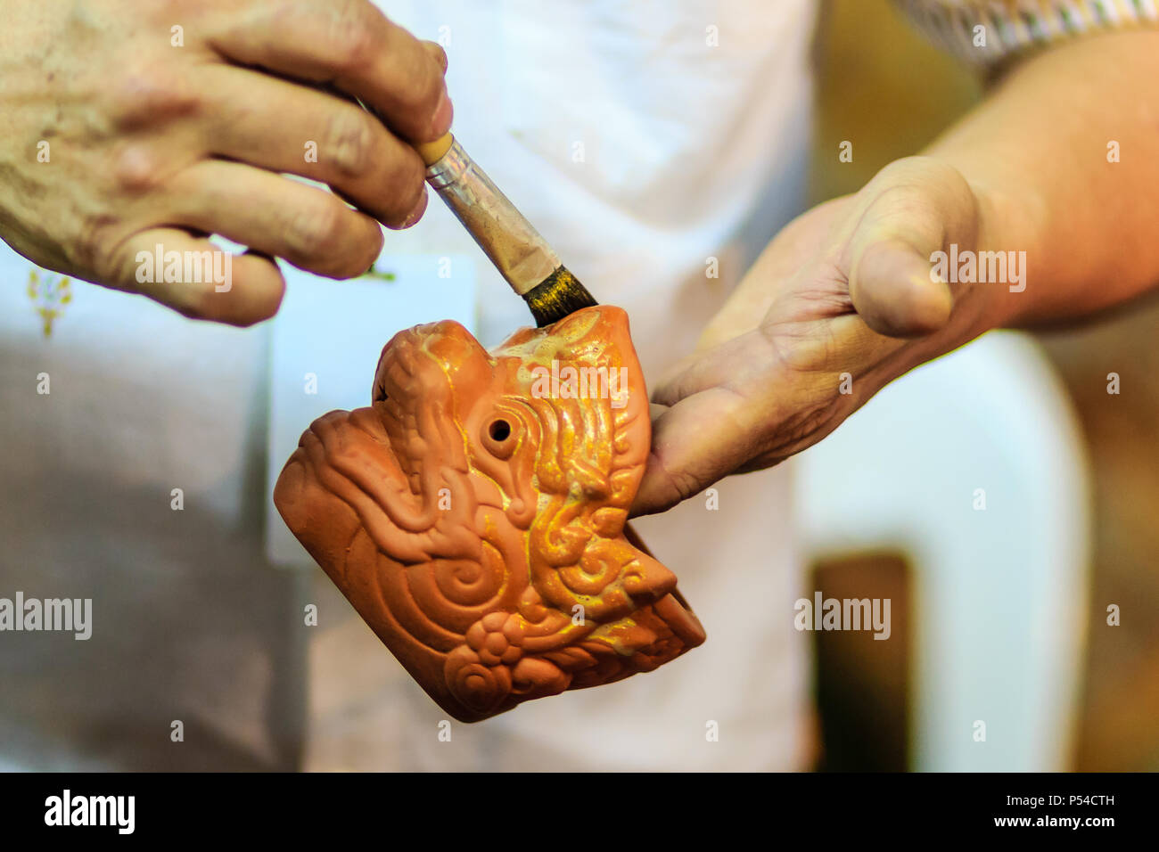 Close up hand of Thai sculptor during painting the masterpiece of ...