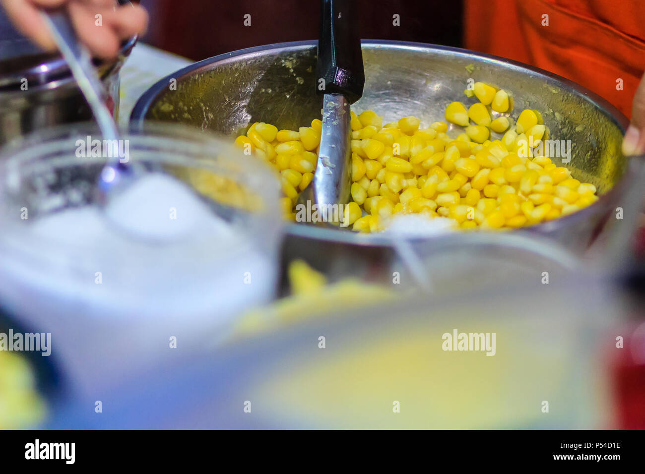 Close up hand of street vendor during cooking for mixed corn butter ...