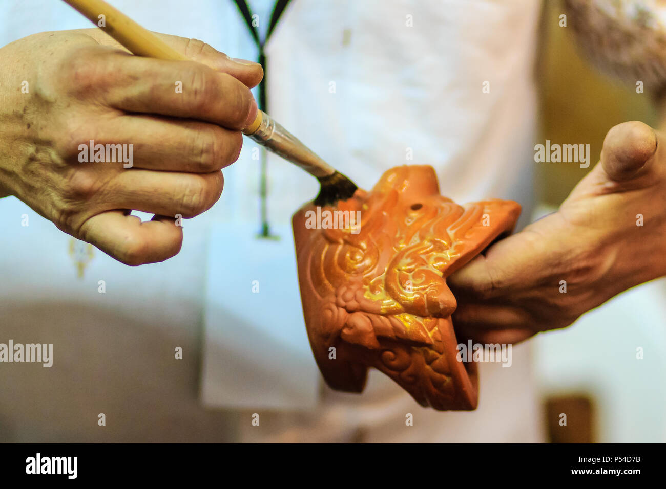 Close up hand of Thai sculptor during painting the masterpiece of ...