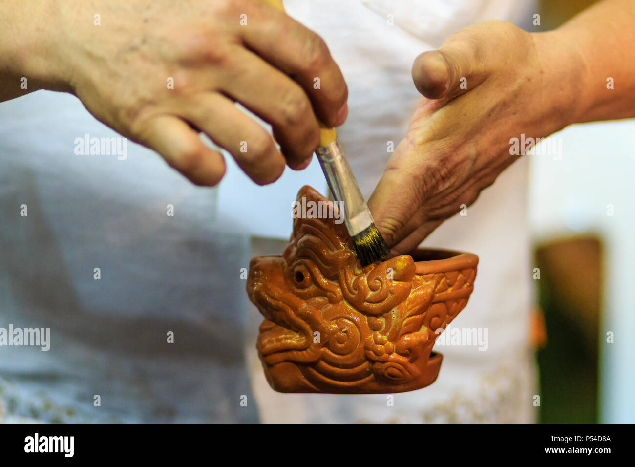 Close up hand of Thai sculptor during painting the masterpiece of ...
