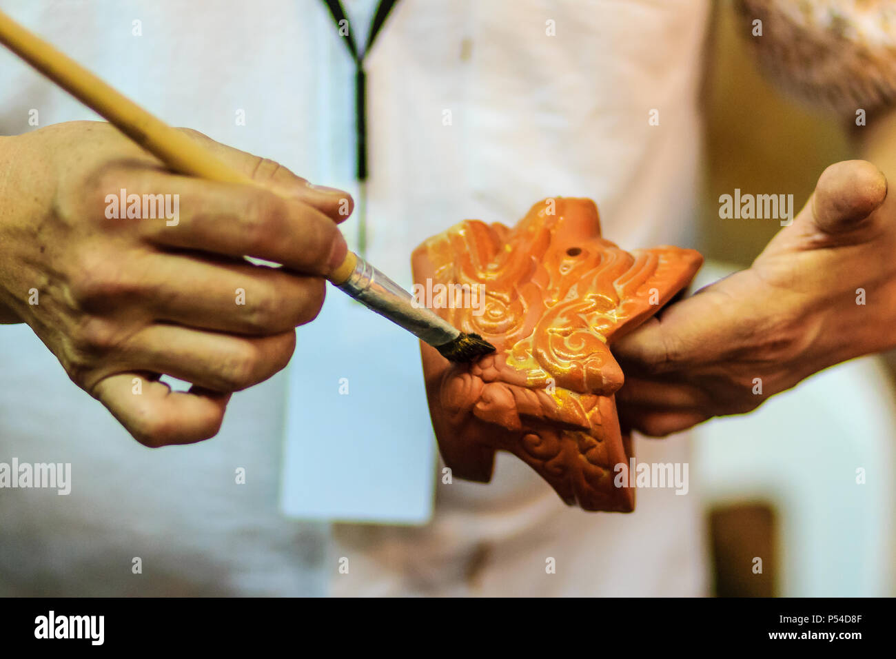 Close up hand of Thai sculptor during painting the masterpiece of ...
