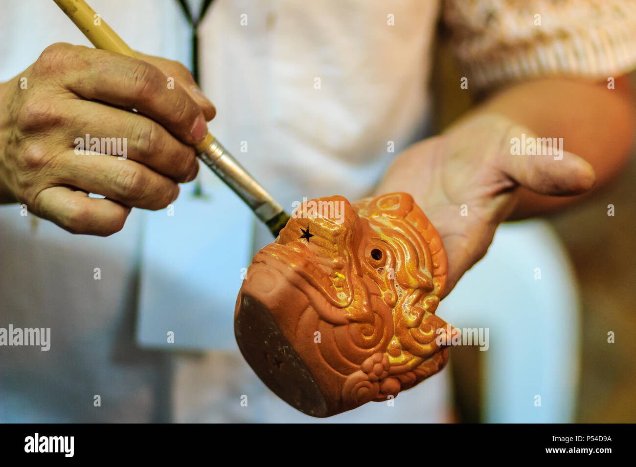 Close up hand of Thai sculptor during painting the masterpiece of ...