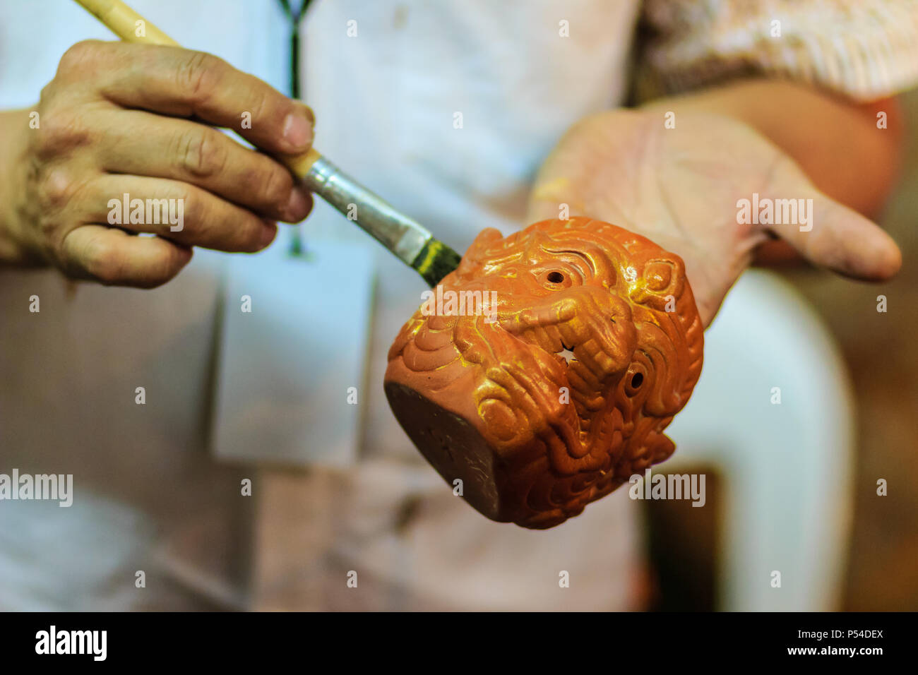 Close up hand of Thai sculptor during painting the masterpiece of ...